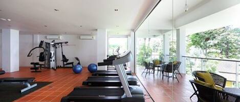 Uma academia com esteiras, bolas de exercício e aparelhos de musculação.