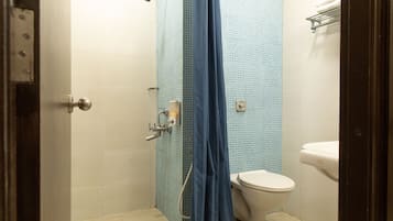 Casa de banho com chuveiro, sanita e um cortina de chuveiro azul.