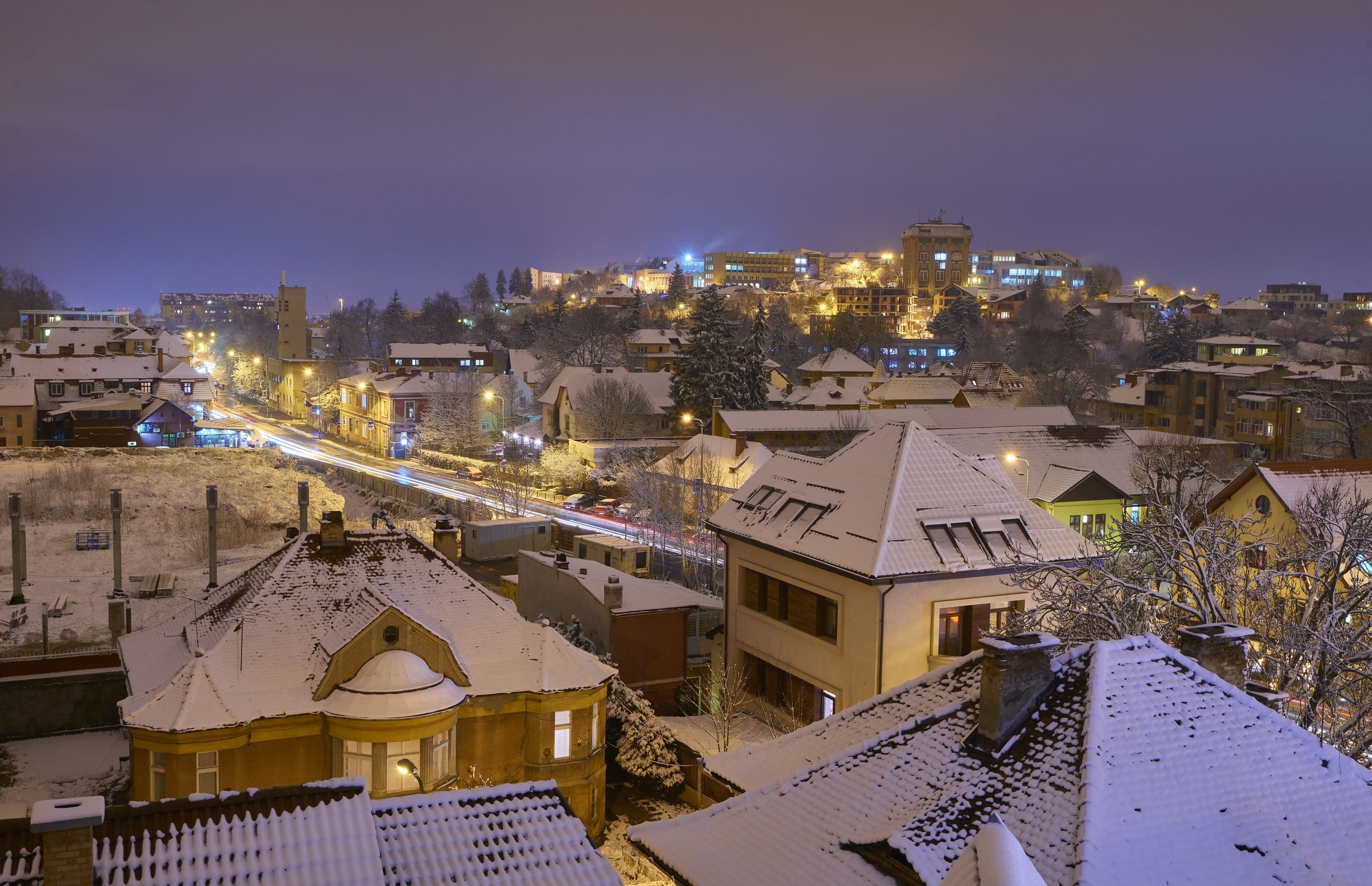 Um bairro residencial coberto de neve, com casas e uma rua.