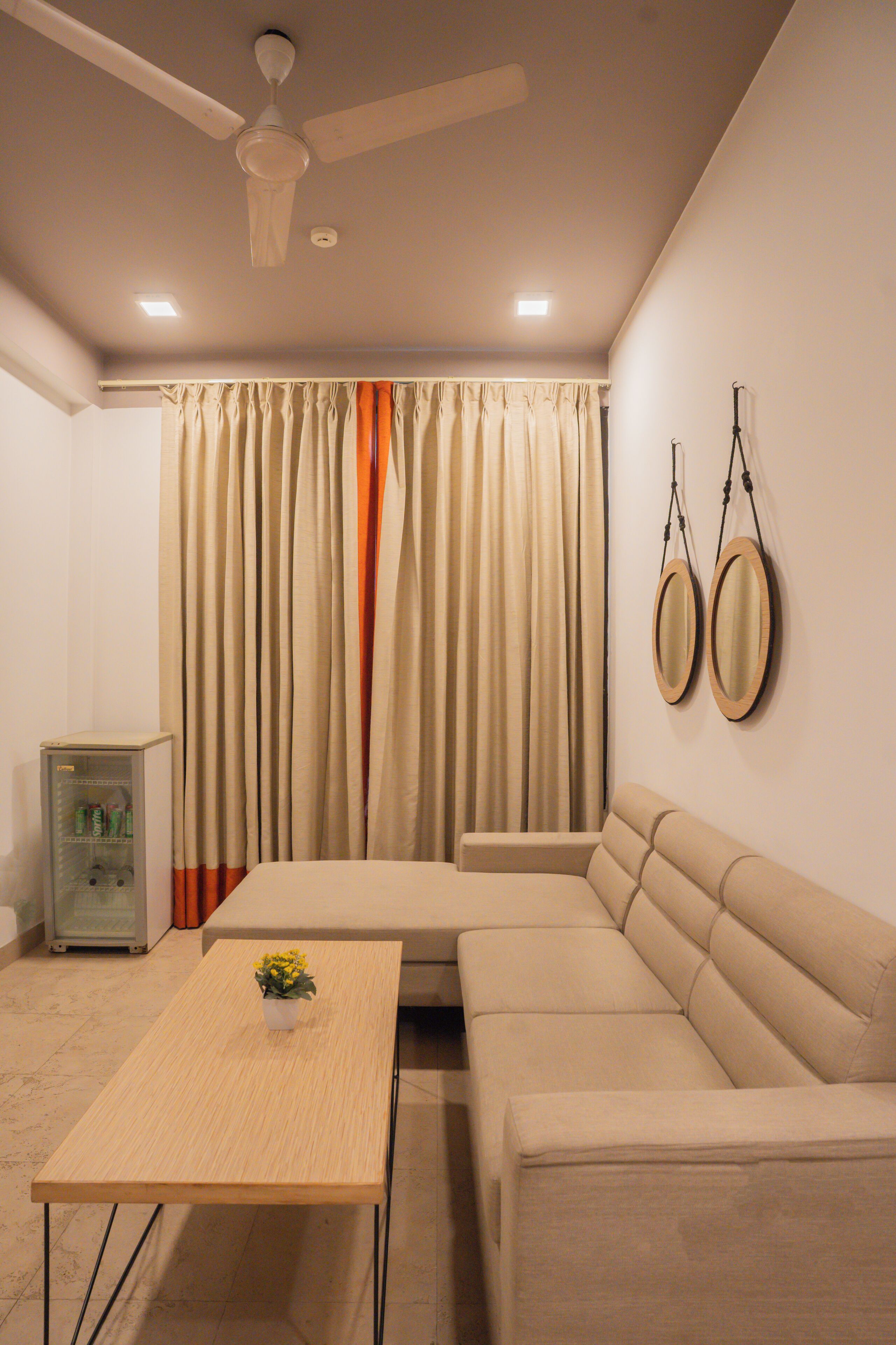 Uma sala de estar moderna com sofá, mesa de centro e ventilador de teto.