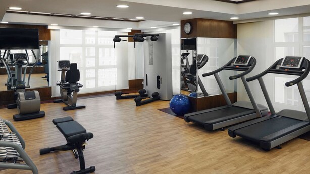 Uma academia com esteiras, bicicletas ergométricas e aparelhos de musculação.