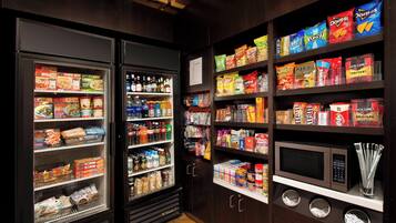 Uma área com máquinas de venda automática, lanches, bebidas e acompanhamentos.