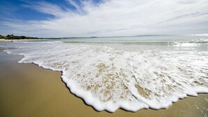 Uma praia com ondas suaves quebrando na costa.