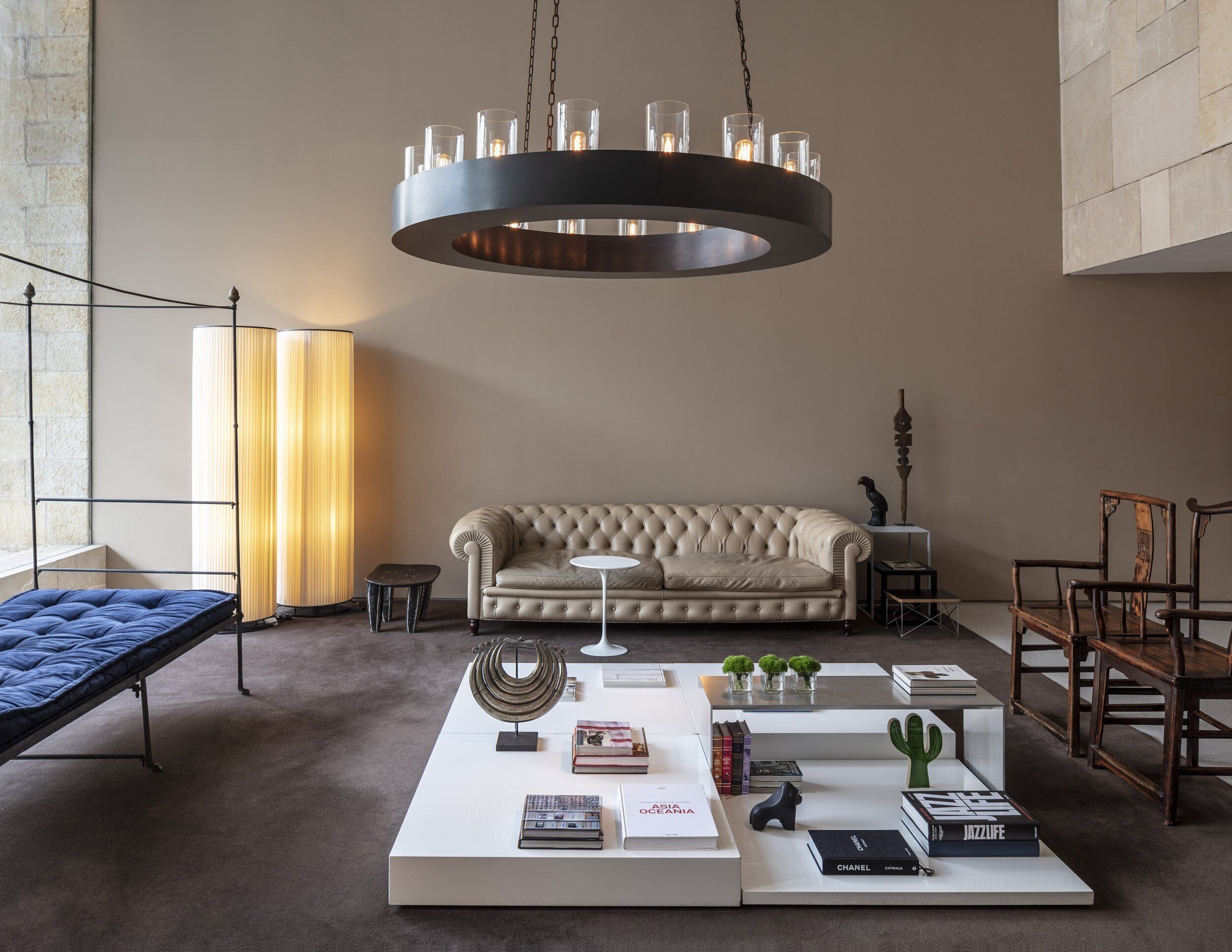 Uma sala de estar moderna com um sofá estofado, uma mesa de centro e um lustre.
