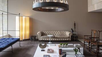Uma sala de estar moderna com um sofá estofado, uma mesa de centro e um lustre.