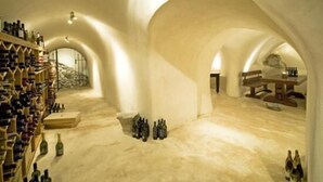 Uma adega com tetos abobadados e estantes de madeira para vinho.