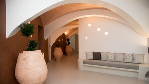Um interior moderno com um banco branco curvo, grandes vasos de terracota e um design minimalista.