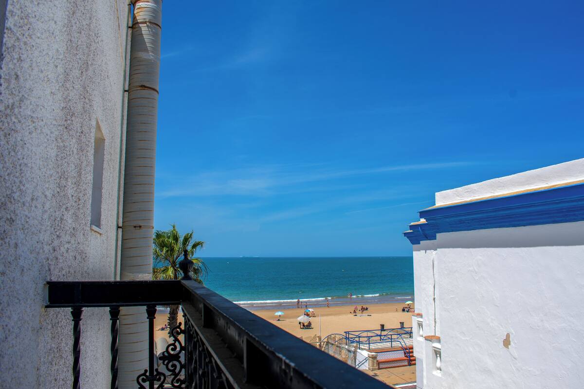Uma varanda com vista para a praia e oceano.