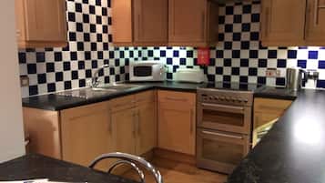 Um frigorífico, um micro-ondas, um forno, uma placa de cozinha