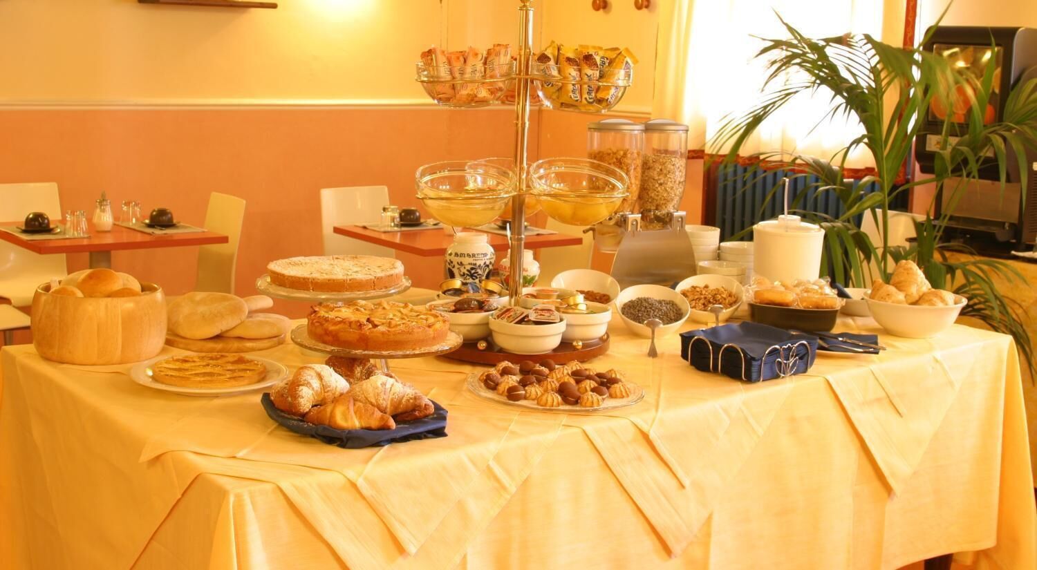 Uma mesa de buffet com diversos alimentos e um espaço para café.