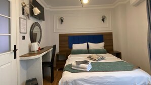 Quarto de hotel com cama, escrivaninha, cadeira e um design de teto exclusivo.