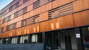 Um edifício moderno com painéis de madeira horizontais e grandes janelas.