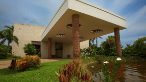 Um edifício moderno com um design arquitetônico único, destacando um telhado inclinado e janelas circulares.