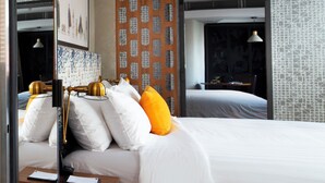 Quarto de hotel com uma cama grande, uma escrivaninha e um espelho.