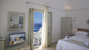 Quarto de hotel com cama, televisão, guarda-roupa e varanda com vista para o mar.