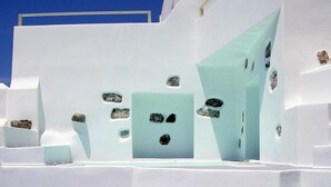 Um edifício branco com vários andares e uma escadaria que leva a uma porta.