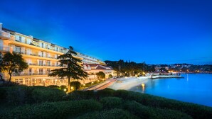 Hotel à beira-mar com várias varandas, área de praia e mar calmo.