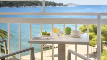Varanda com mesa posta para o café da manhã, com vista para a costa.