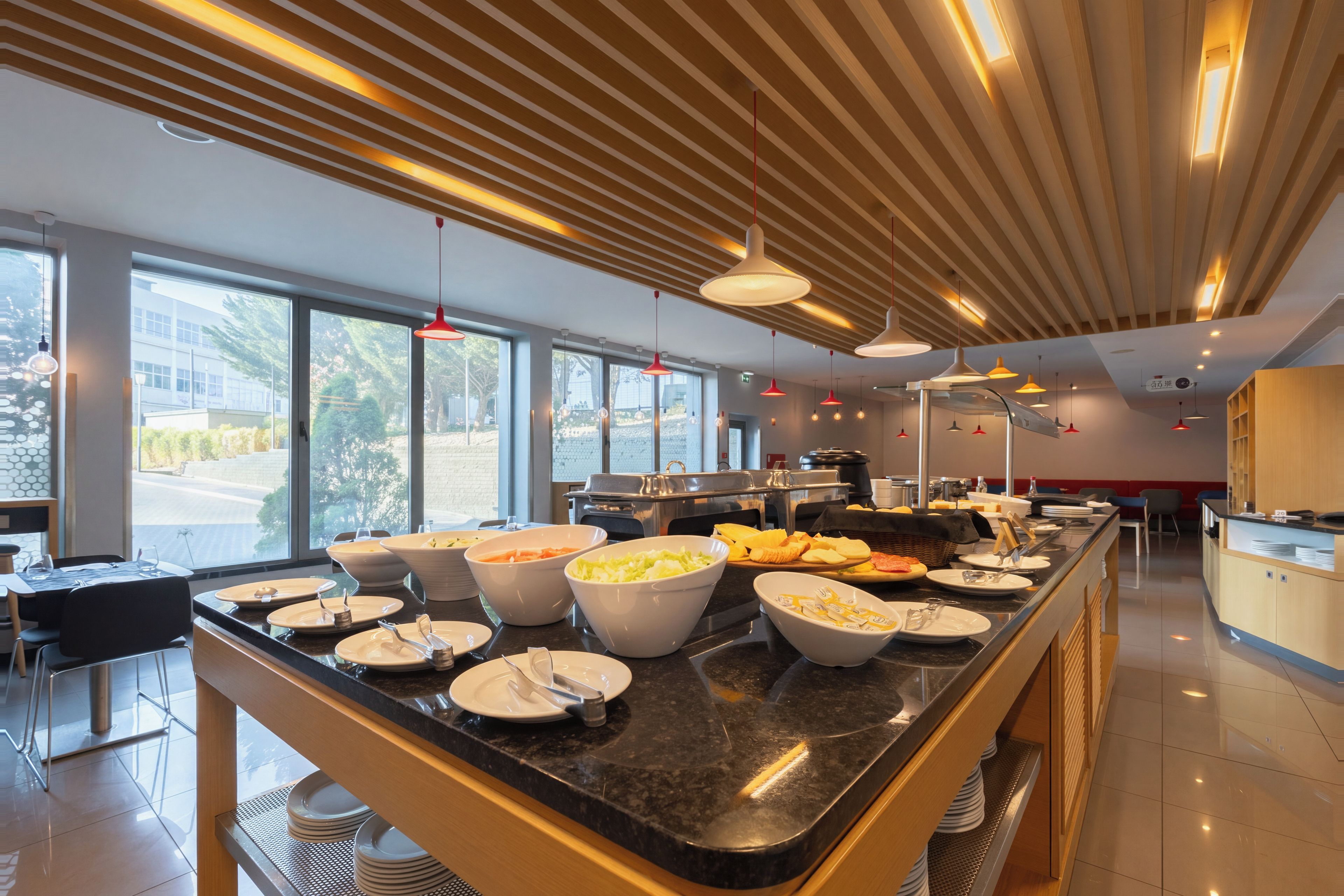Cozinha moderna com ilha central, grandes janelas e vista para o exterior.