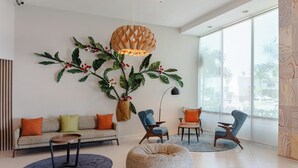 Uma sala de estar moderna com sofá, cadeiras, mesa de centro e uma luminária pendente única.