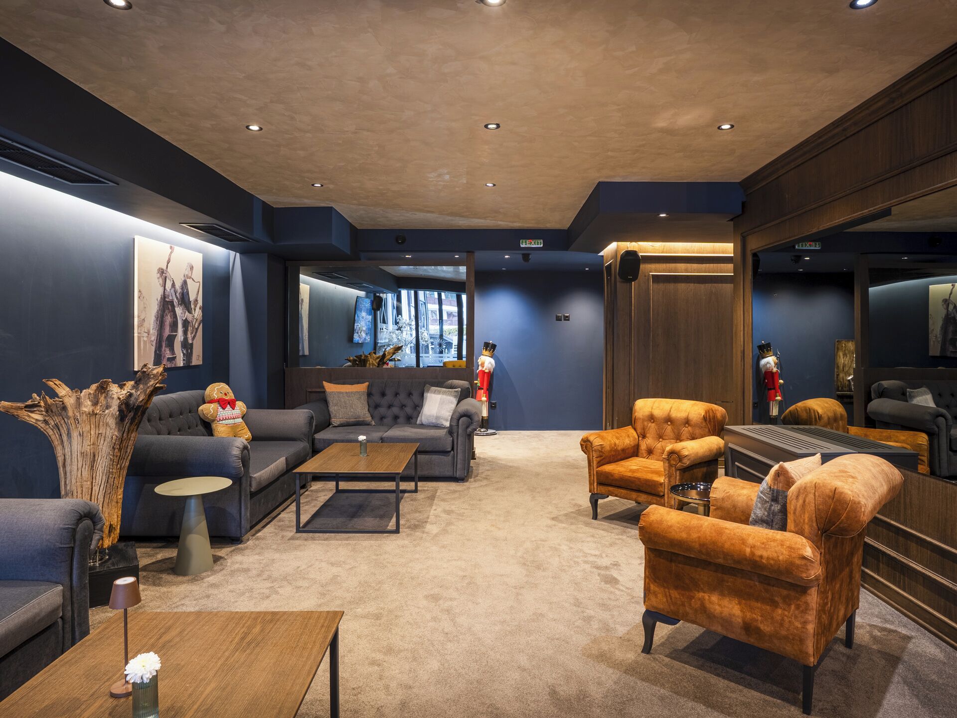 Uma sala de estar moderna com sofá, poltronas, mesa de centro e lareira.