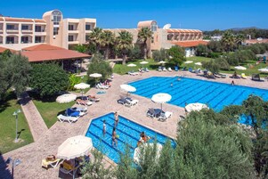 Um hotel com uma piscina grande, espreguiçadeiras e guarda-sóis.