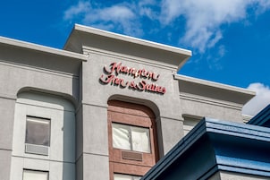 Um edifício com uma placa que diz 'Hampton Inn & Suites'.