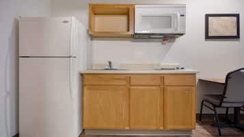 Um frigorífico/congelador grande, um micro-ondas, uma placa de cozinha