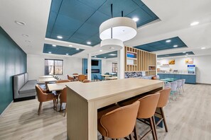 Uma sala de jantar moderna com ilha central, diversas opções de assento e teto com iluminação embutida.