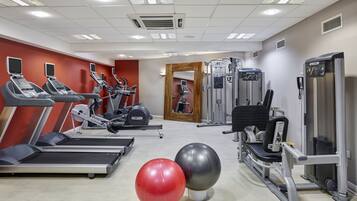 Uma academia com esteiras, elípticos e equipamentos de musculação.
