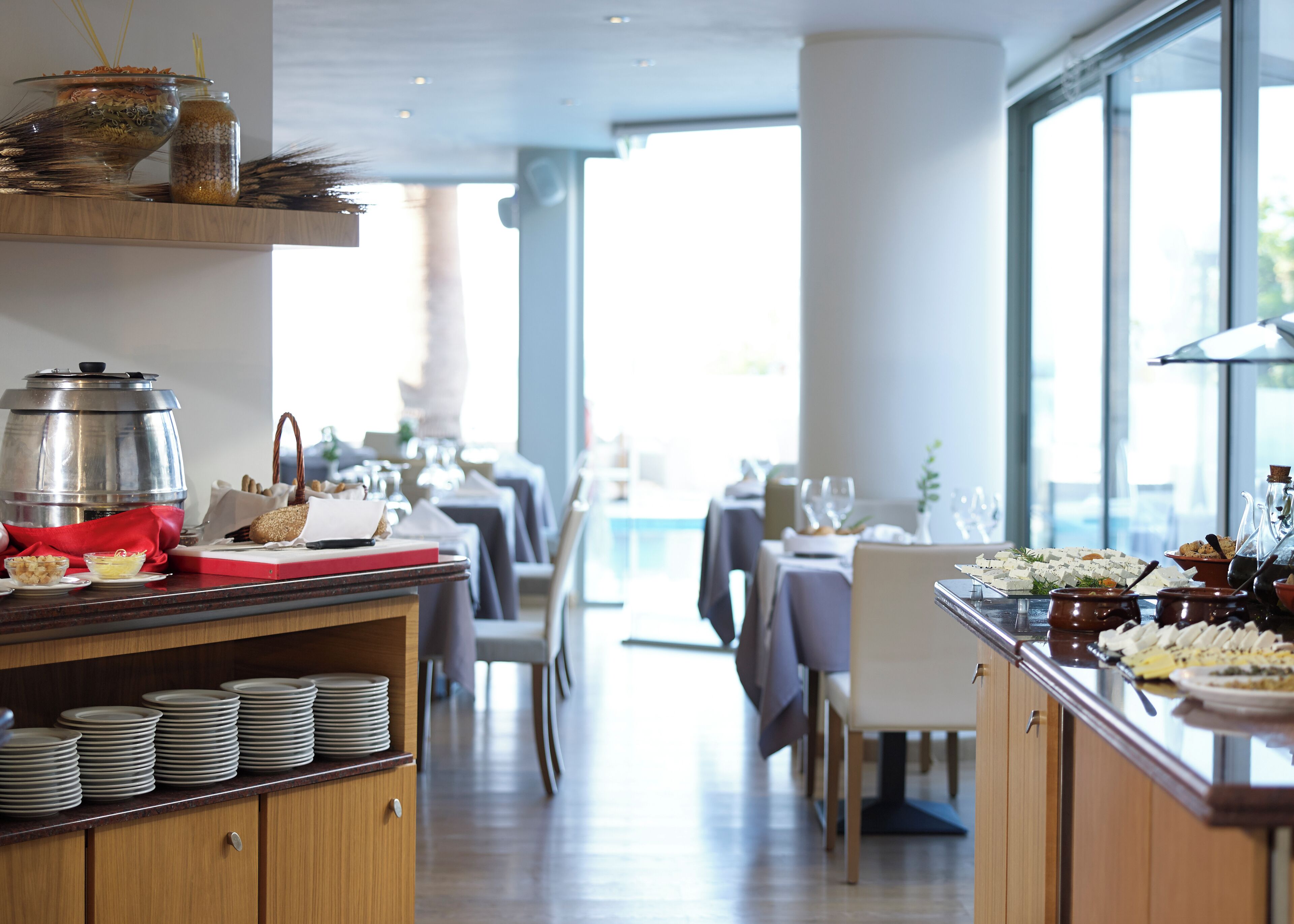 Espaço de refeições de hotel com serviço de buffet, incluindo diversas opções de comida e um canto de café.