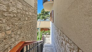 Um beco estreito com paredes de pedra e um corrimão de madeira.