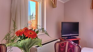 Quarto com janela, televisão e uma cadeira.
