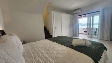 Quarto com cama, escada e varanda com vista.