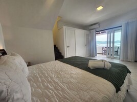 Quarto com cama, escada e varanda com vista.