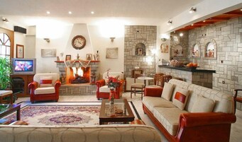 Uma sala de estar acolhedora com lareira, assentos confortáveis e uma televisão.