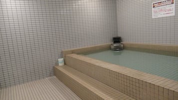 Uma casa de banho com azulejos, banheira, sanita e lavatório.