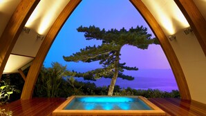 Uma área de spa com arco de madeira e vista para o mar.