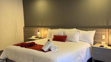 Um quarto moderno com uma cama grande, mesas de cabeceira e um criado-mudo.