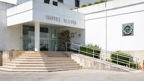Entrada moderna de hotel com uma escadaria que leva ao saguão.