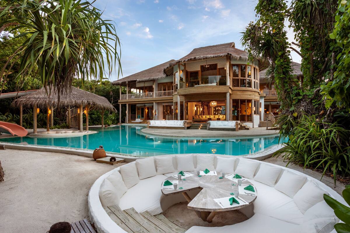 Resort com piscina, área de estar externa e um edifício grande com várias varandas.