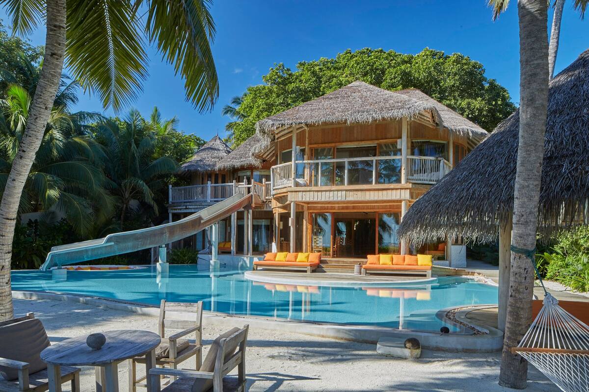 Um resort com piscina, espreguiçadeiras e um tobogã.