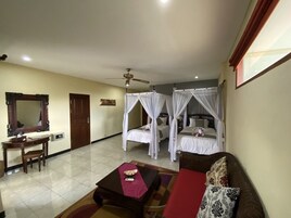 Quarto de hotel com cama, sofá, escrivaninha e cadeira.