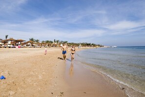 Uma praia privada, guarda-sóis de praia, toalhas de praia, mergulho