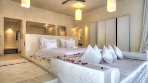 Quarto de hotel moderno com uma cama grande, um espaço de estar e um closet espaçoso.