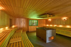 Uma sauna com bancos de madeira e um elemento central de pedras aquecidas.