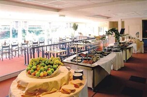Uma mesa de buffet com diversos alimentos e uma apresentação de frutas.