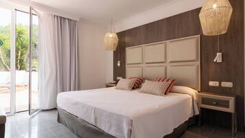 Quarto moderno com uma cama grande, cabeceira de madeira, mesa de cabeceira e luminária pendente.