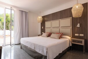 Quarto moderno com uma cama grande, cabeceira de madeira, mesa de cabeceira e luminária pendente.