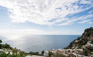 Uma vila costeira com edifícios ao longo do penhasco, com vista para o mar.